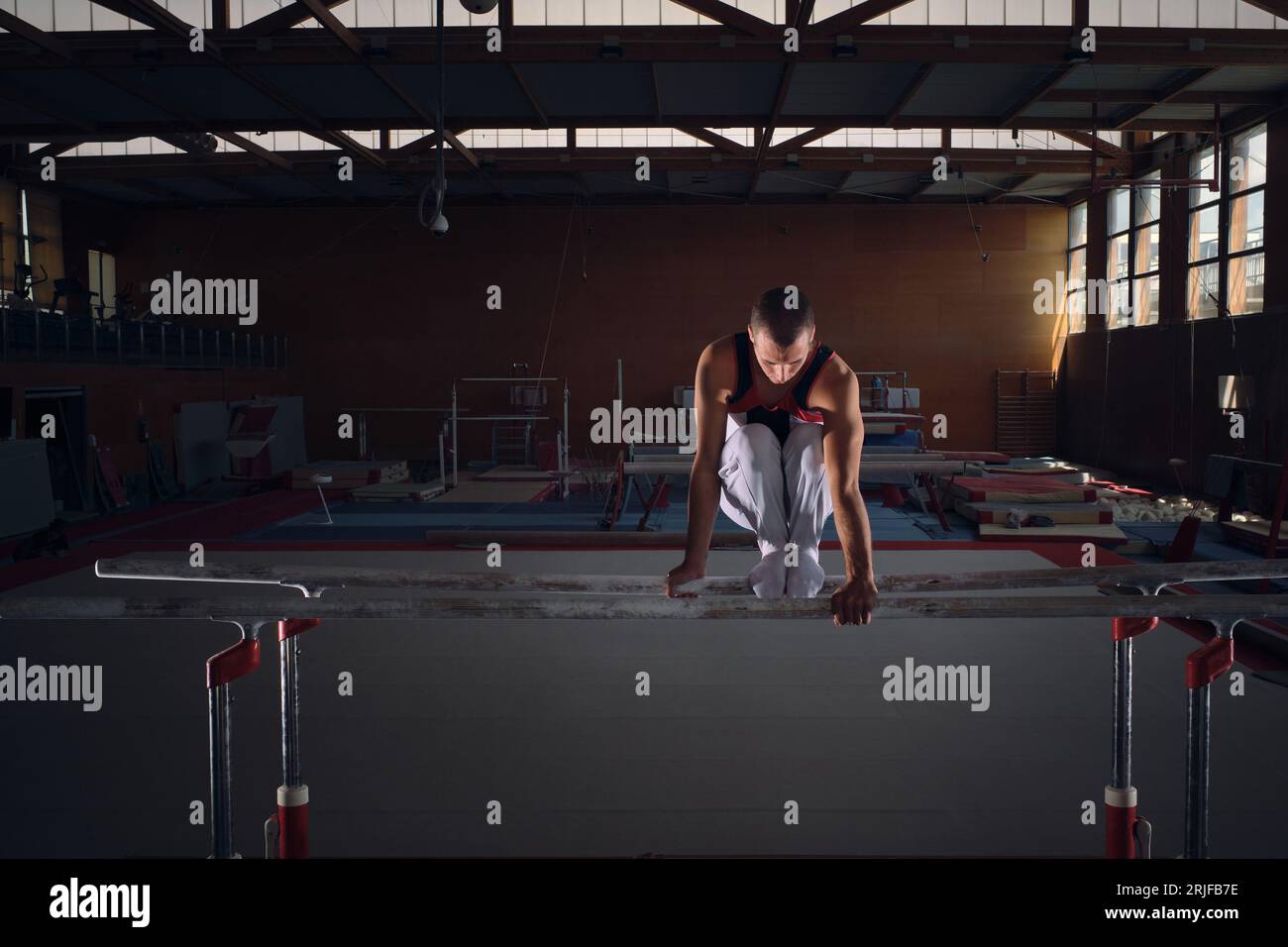 Young male gymnast doing exercises on the parallel apparatus Stock ...