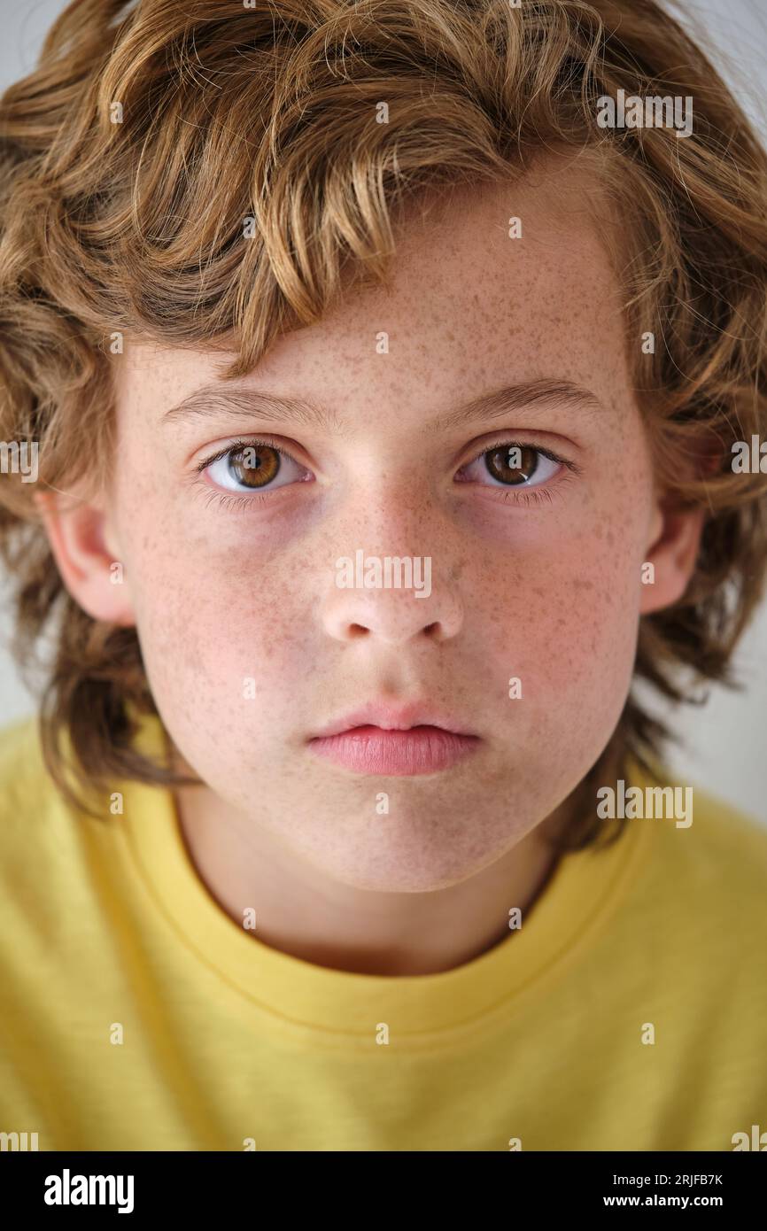 Serious child in yellow casual wear with brown hair and freckles ...