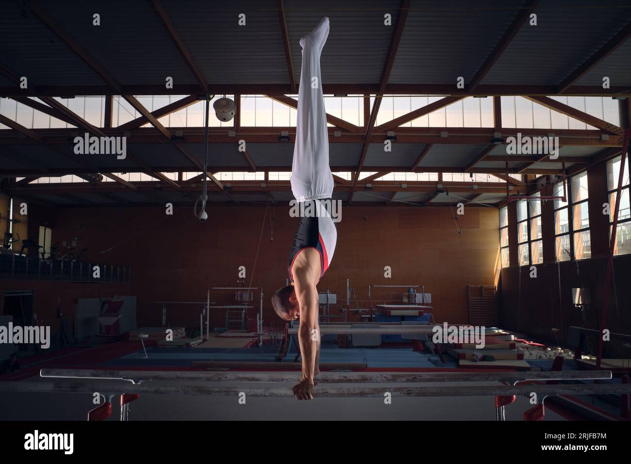 Young male gymnast doing exercises on the parallel apparatus Stock ...