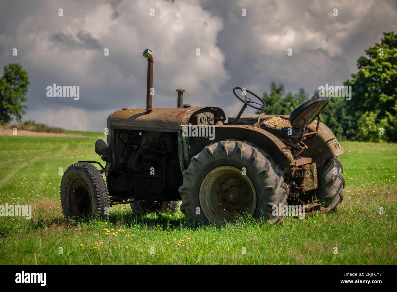 Scenic countryside with a old historic tractor in a field ready for ...