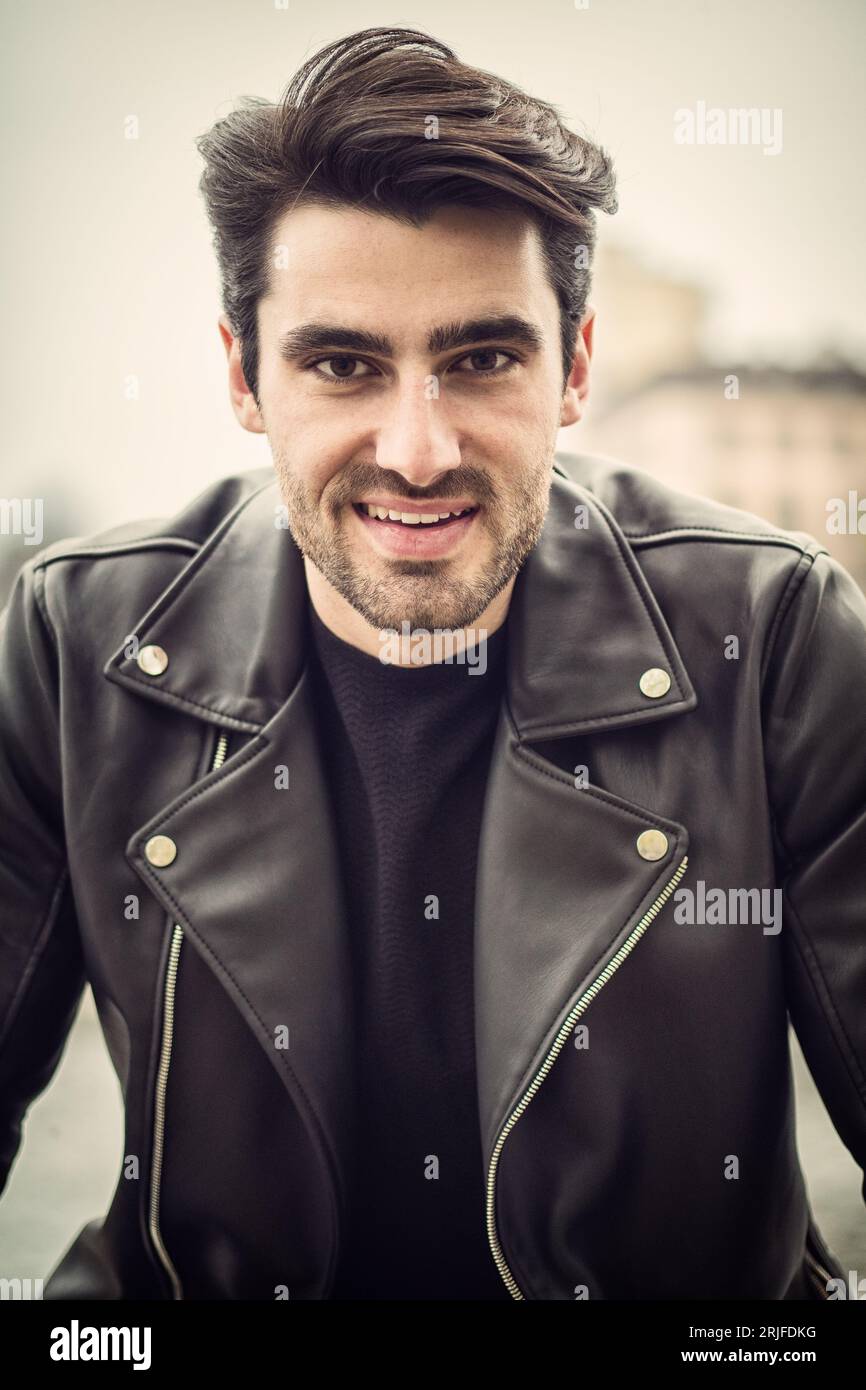 A man in a leather jacket smiling for the camera Stock Photo - Alamy
