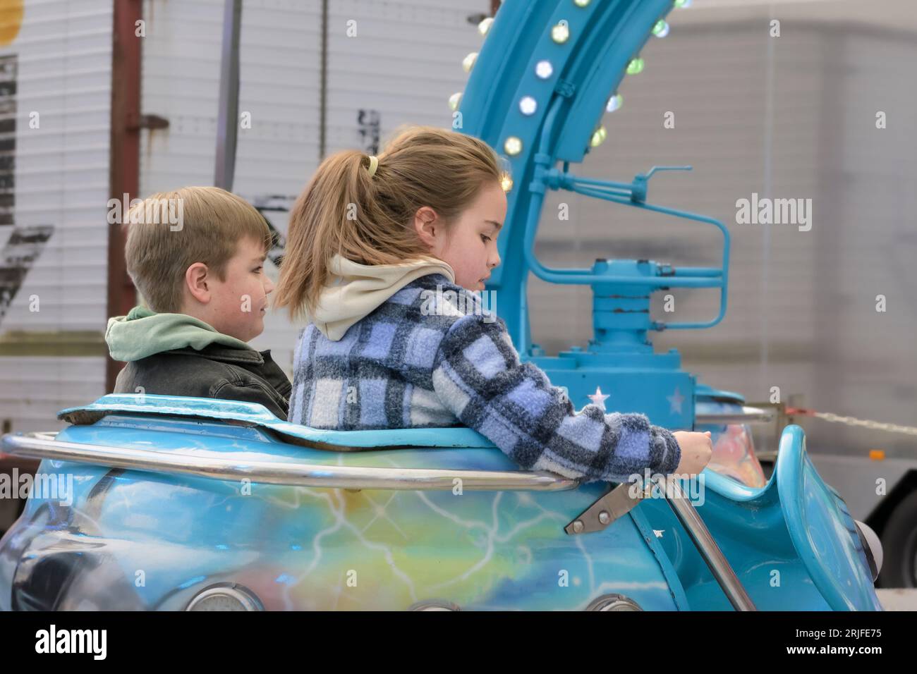 Amusement park ride safety. Kid herself checks the security of the lock ...