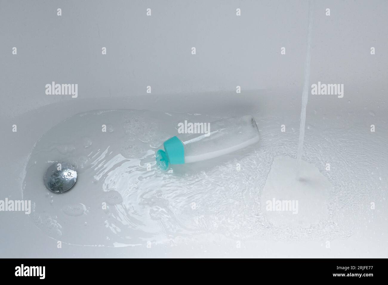 An empty shampoo container is lying around in the bathroom, the remains ...
