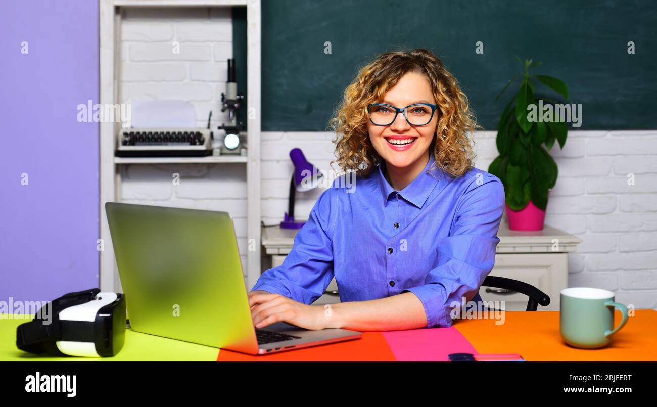 High school. Female teacher in glasses working with notebook computer ...
