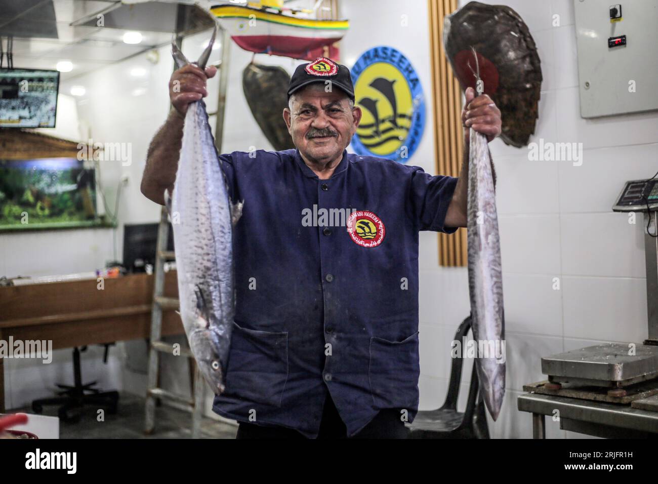 A Palestinian fisherman displays fish in the central fish market called ...