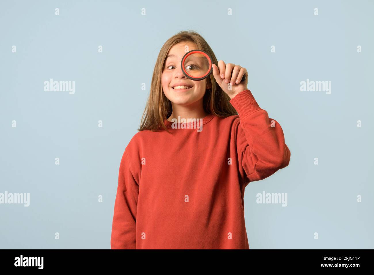 Young researcher. Portrait of an inquisitive girl with a magnifying ...