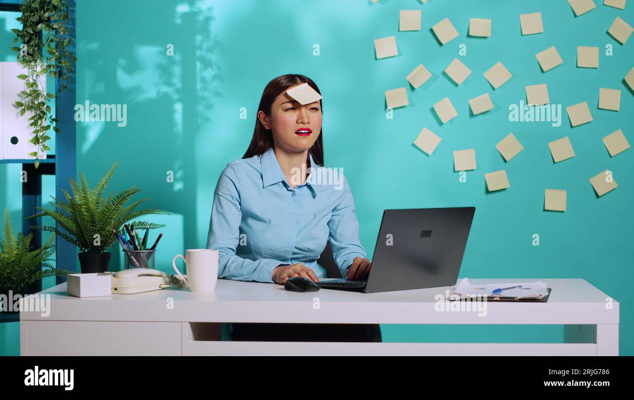 Playful asian employee having fun in colourful bright office, playing ...