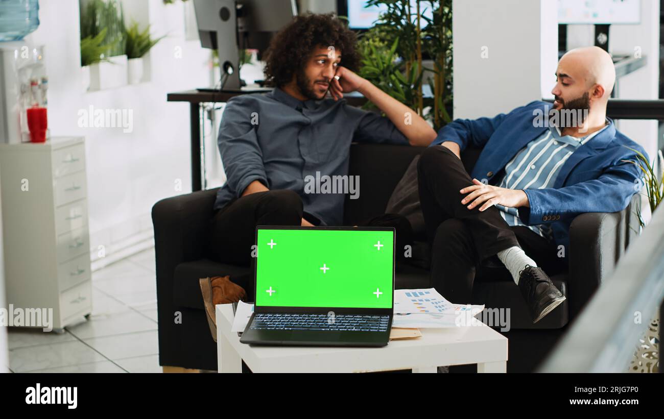 Greenscreen display on laptop in office, business partners discussing ...