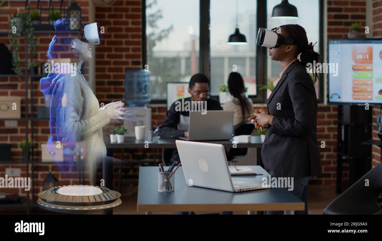 Employee wearing VR goggles with hologram supervisor. Businesswoman at ...