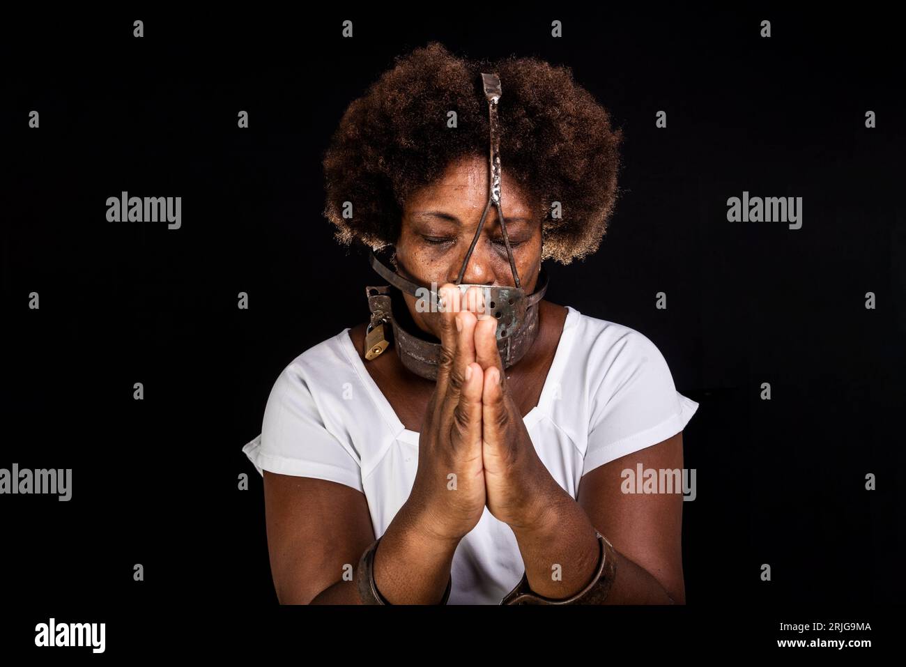 Black woman in chains with an iron mask on her face, representing the ...