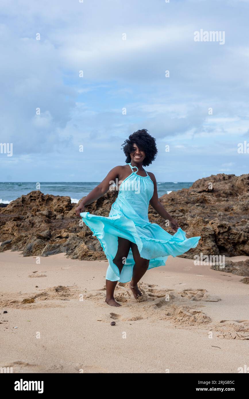 Beautiful woman with black power hair wearing long light blue outfit ...