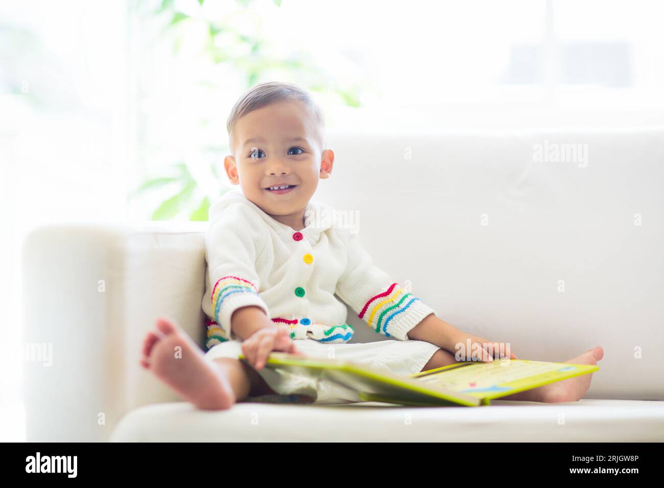 Baby boy reading a book. Kids read. Adorable Asian child holding a fun ...