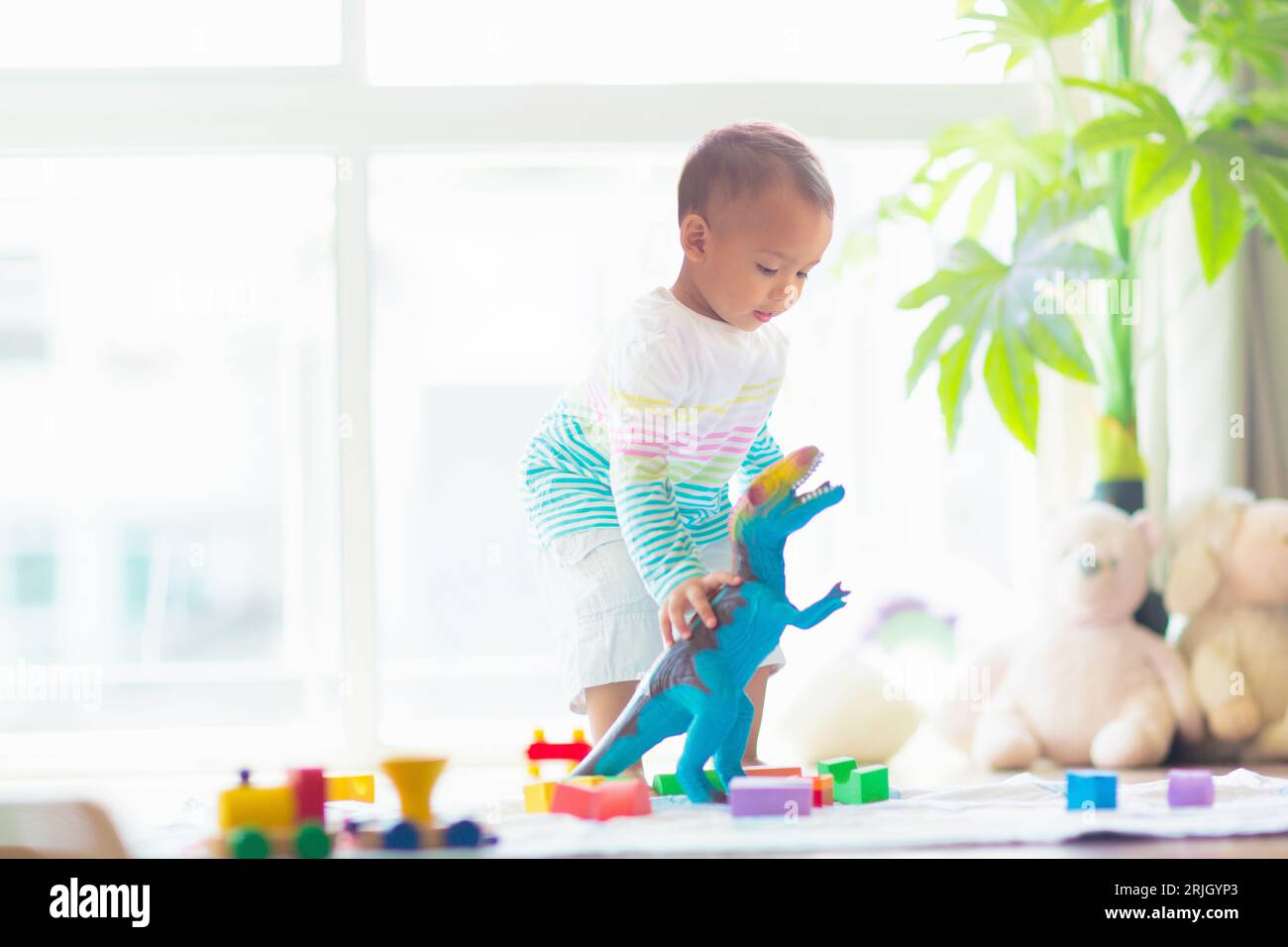 Adorable Asian baby boy learning to crawl and playing with colorful ...
