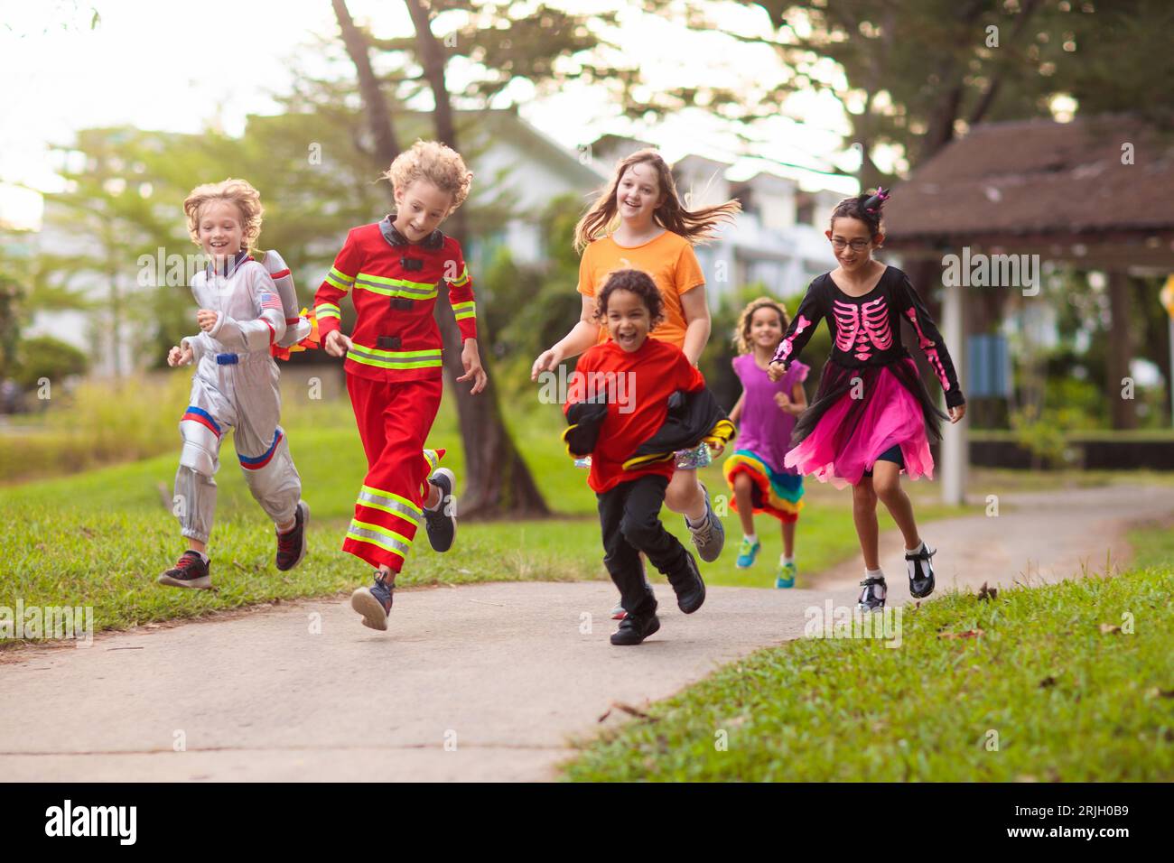 Child in Halloween costume. Mixed race kids and parents trick or treat ...