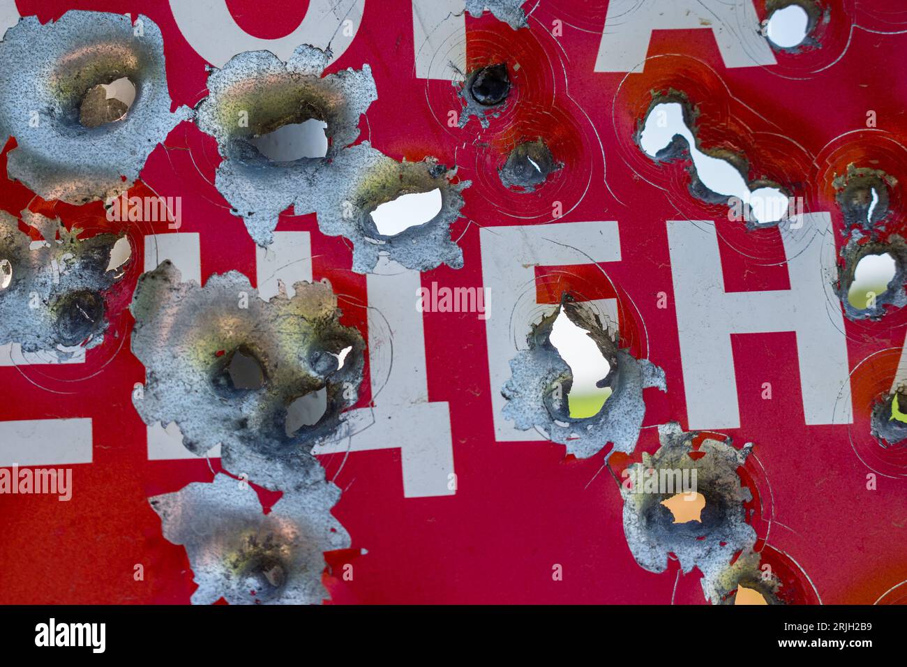 Entrance through bullet holes from gunshot in a metal sheet close up ...