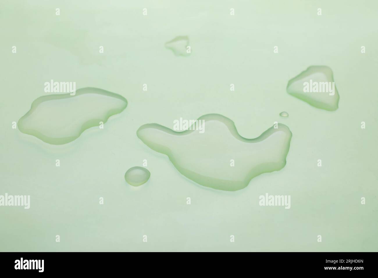 Puddle of water on light green background Stock Photo - Alamy