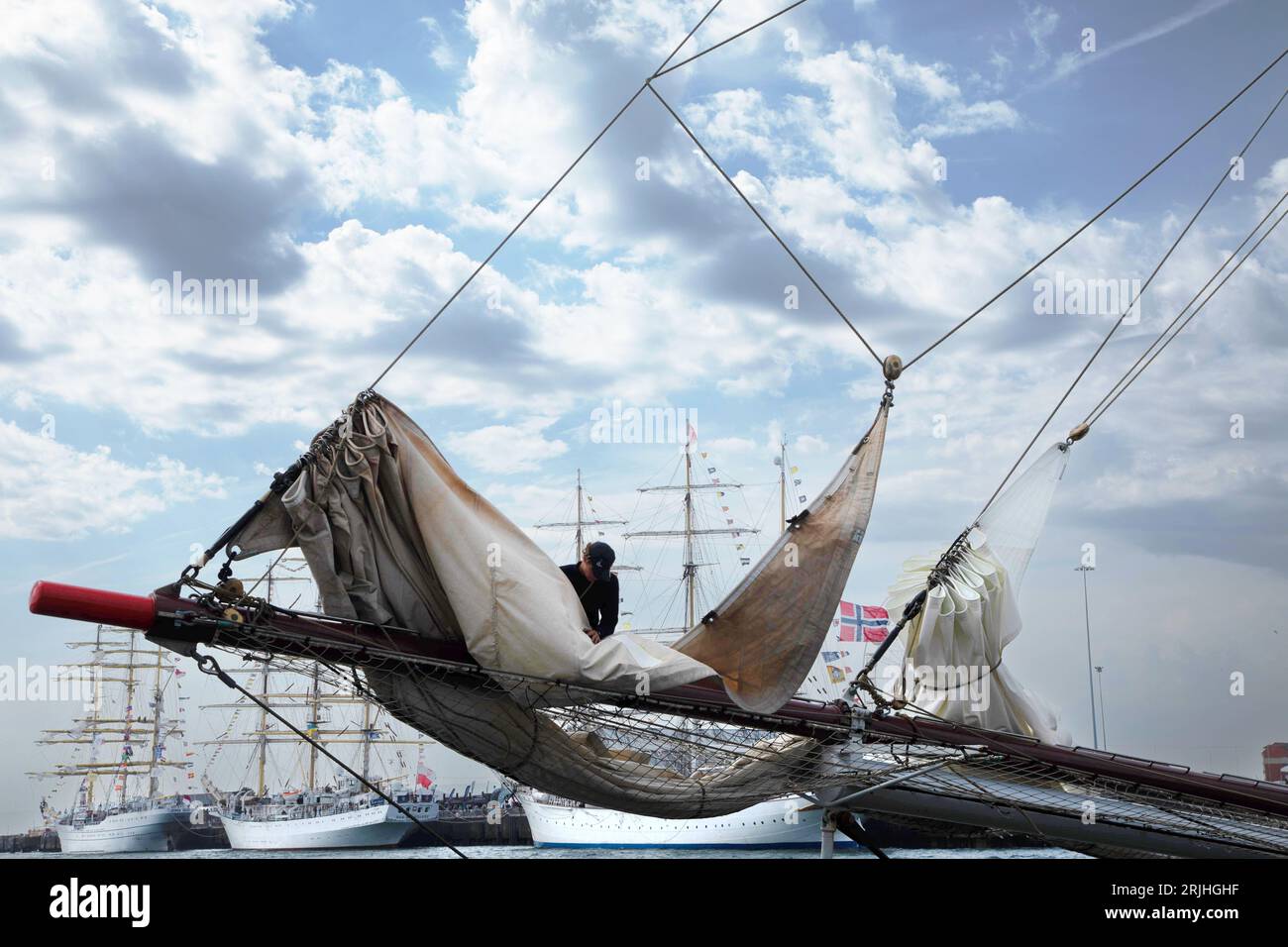 Several majestic tall ships are captured sailing side by side in a calm ...