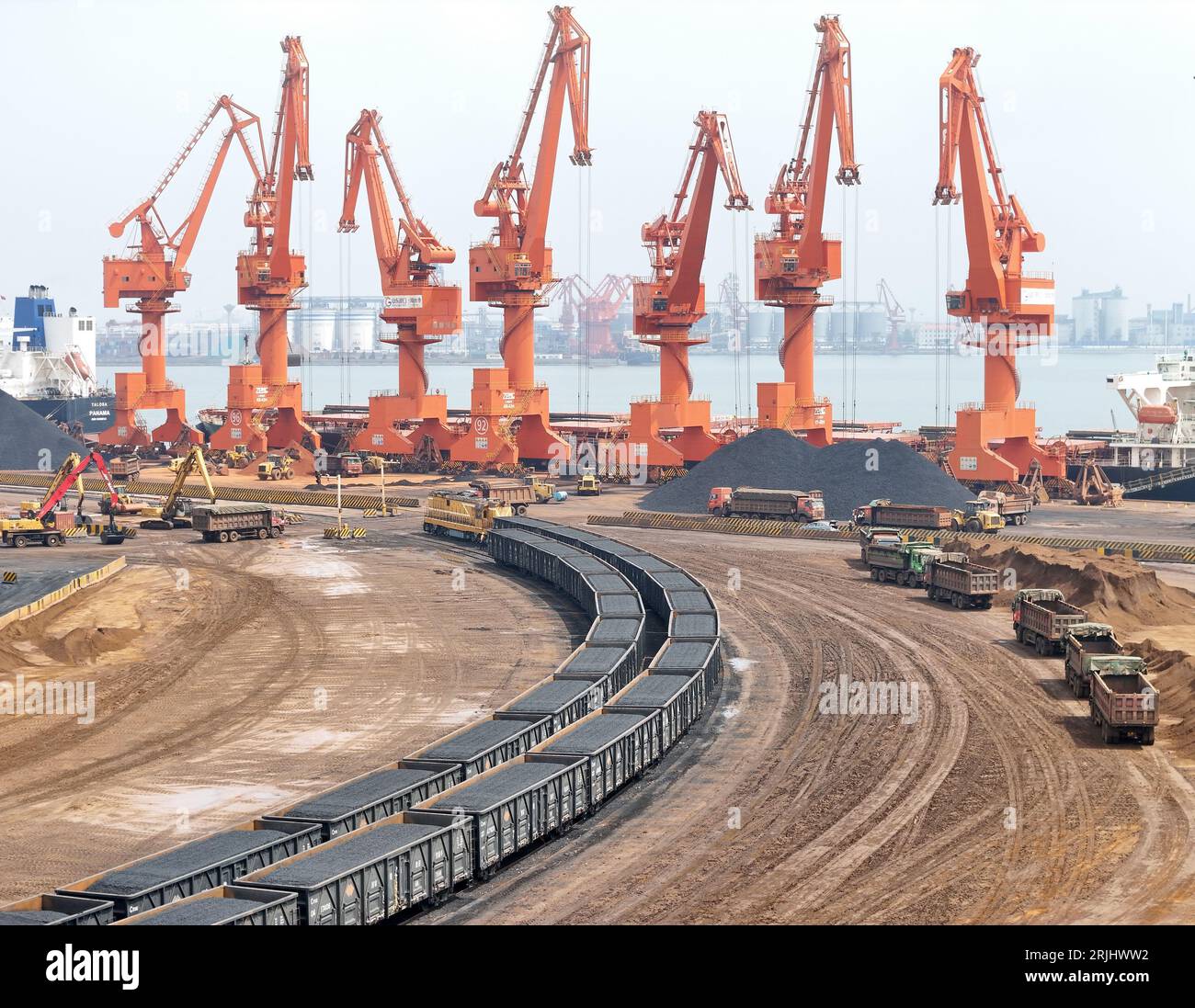 YANTAI, CHINA - AUGUST 22, 2023 - Cargo ships and trains transport coal ...