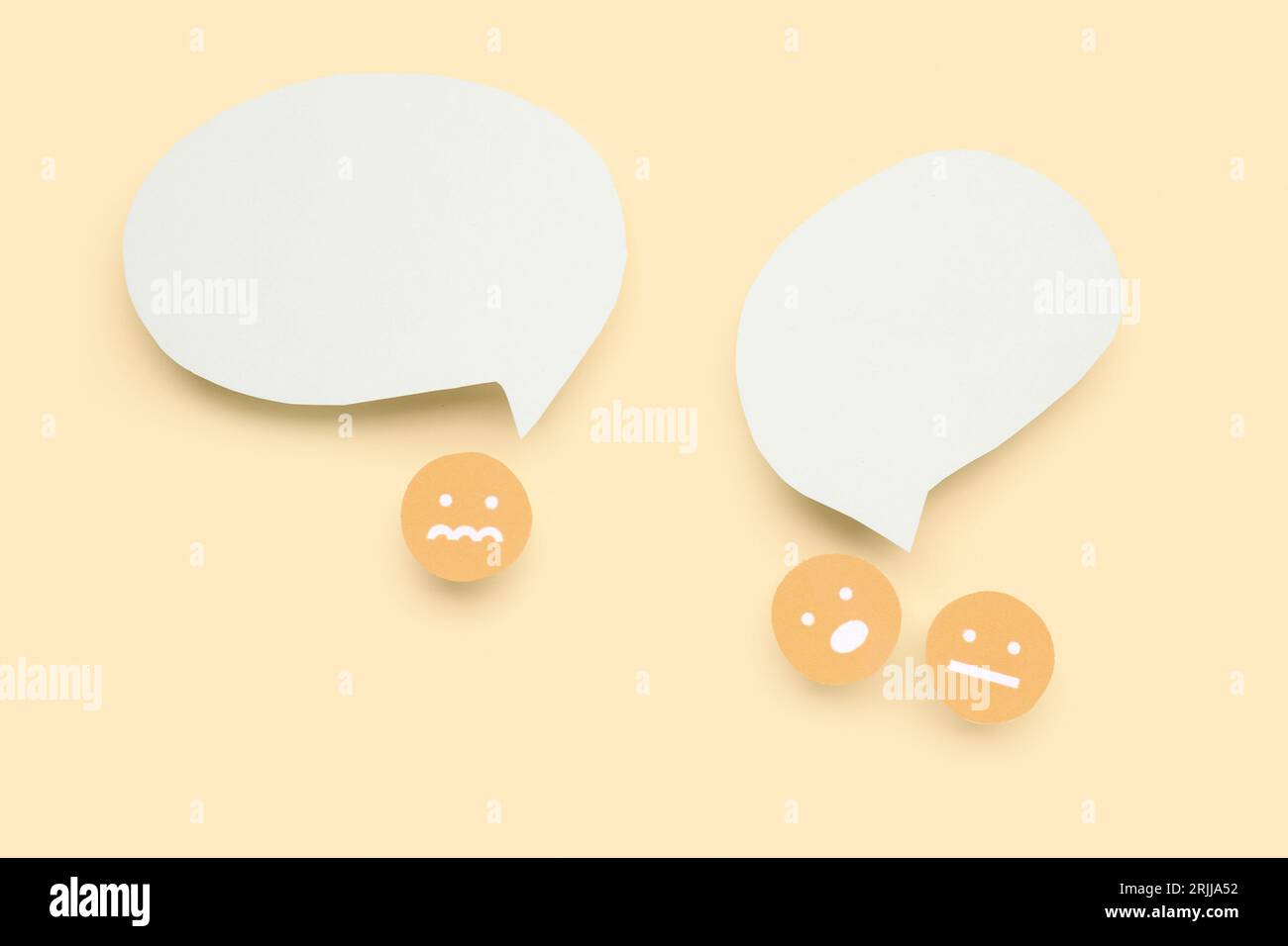 Paper faces with blank speech bubbles on yellow background Stock Photo ...