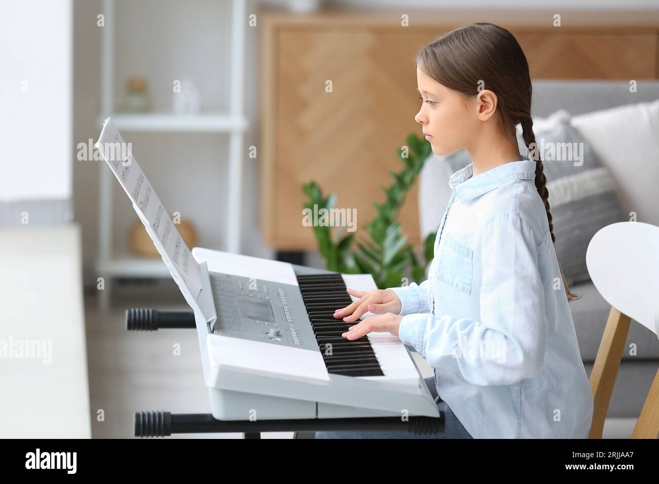 Little girl playing synthesizer at home Stock Photo - Alamy