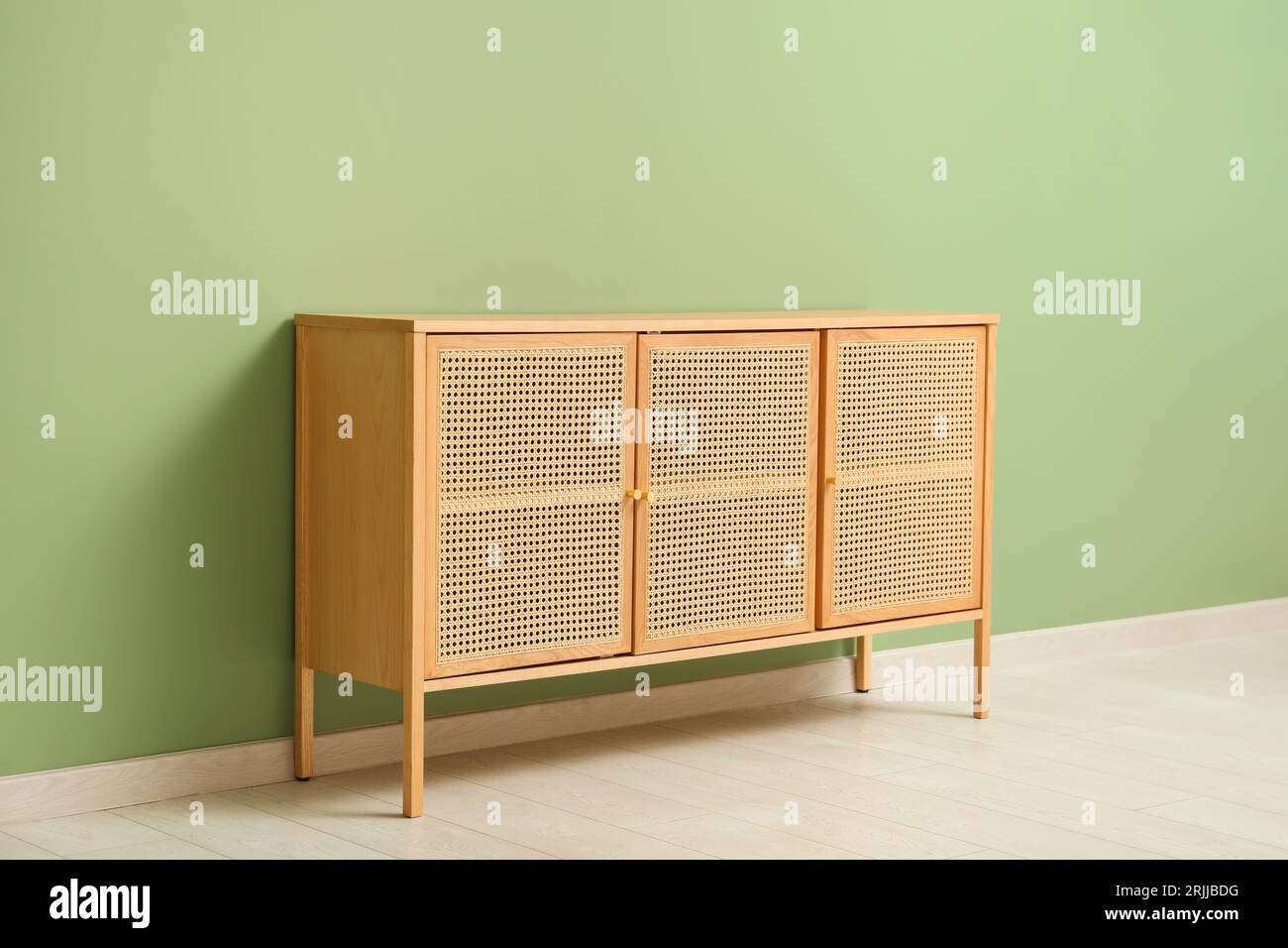 Light wooden chest of drawers near green wall Stock Photo - Alamy