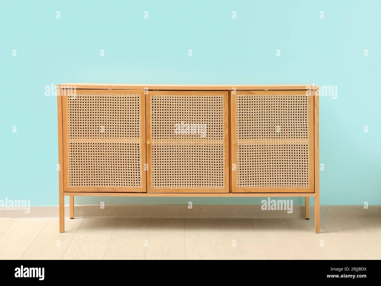 Light wooden chest of drawers near blue wall Stock Photo - Alamy