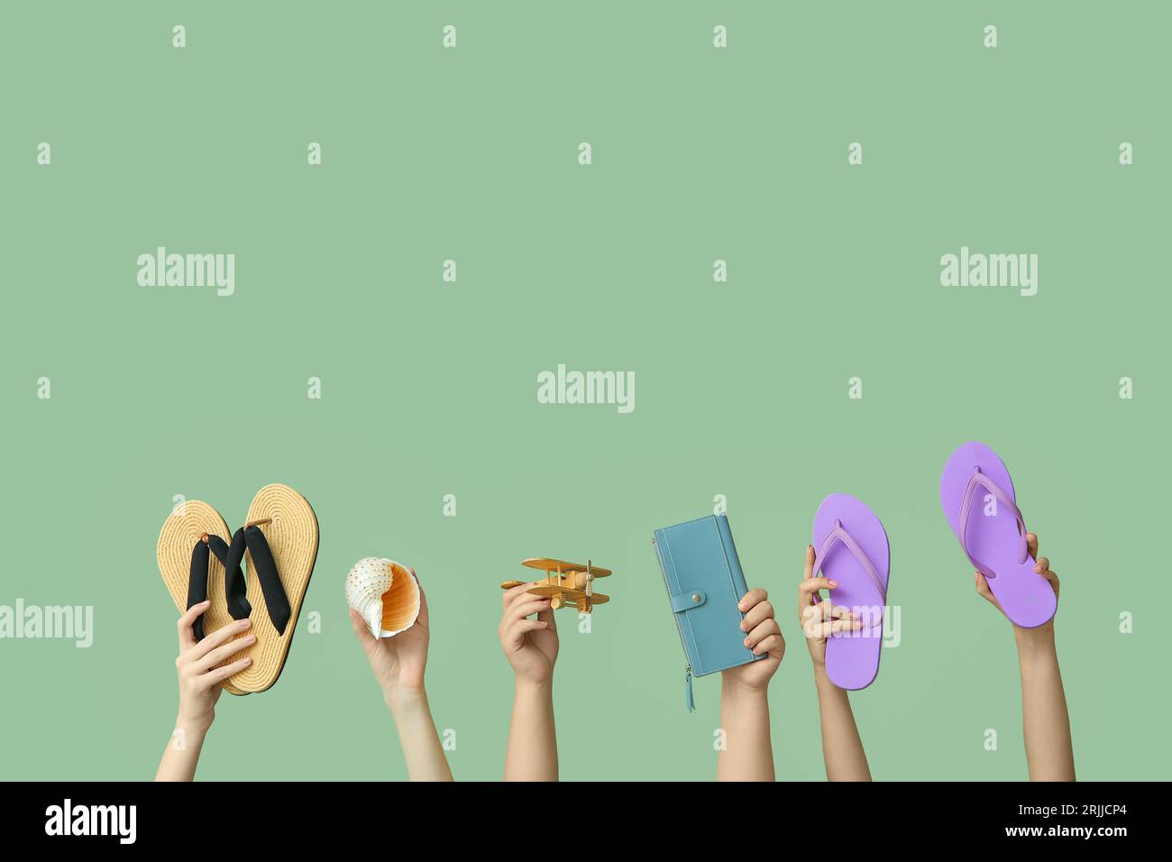 Female hands with flip flops, sea shell, wallet and wooden airplane on ...