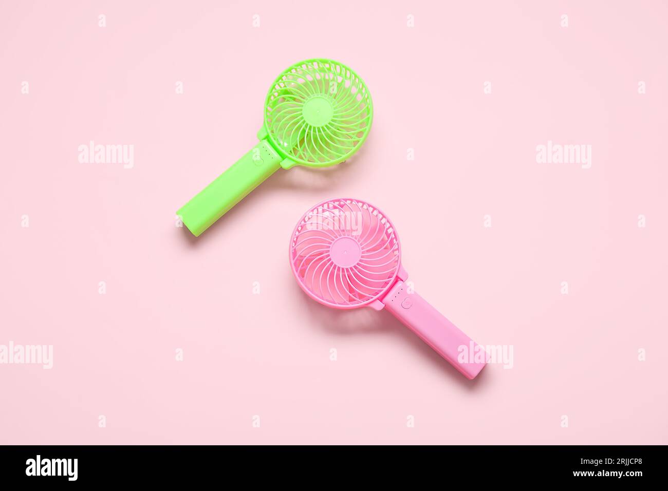 Different portable electric fans on pink background Stock Photo - Alamy