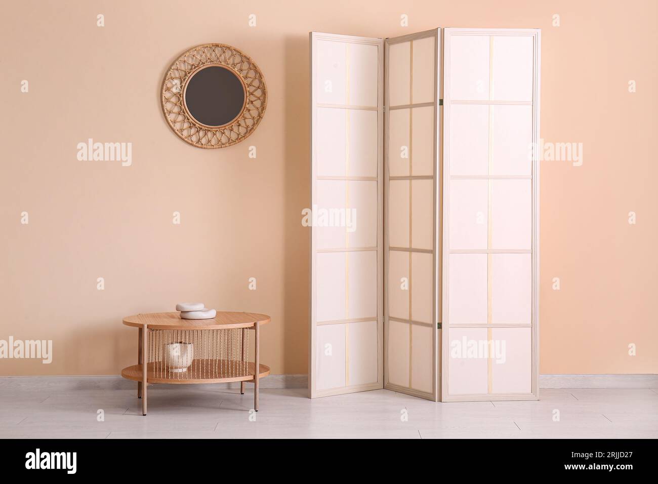 Folding screen, mirror and coffee table near beige wall Stock Photo - Alamy