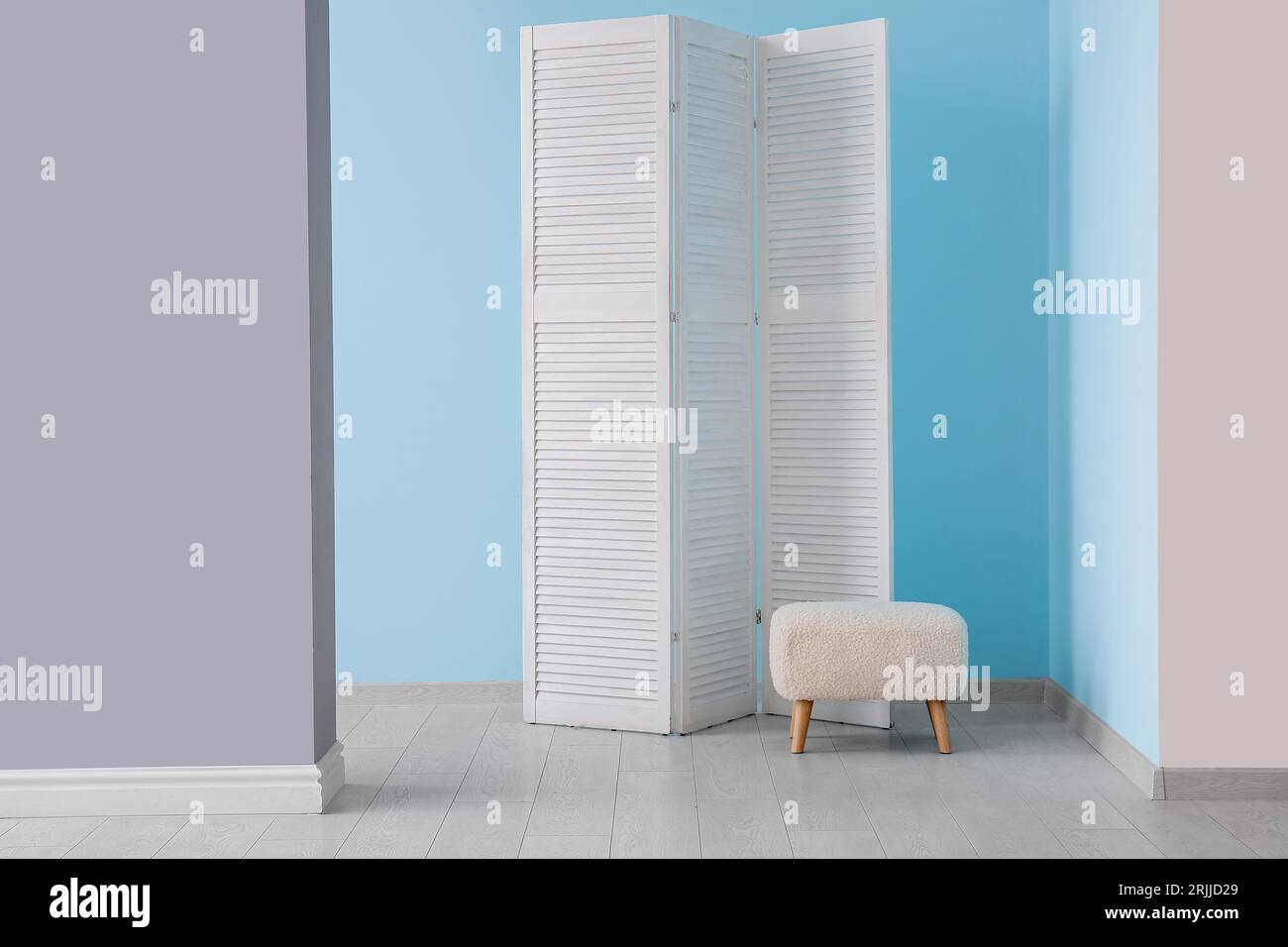 Folding screen and ottoman near colorful wall Stock Photo - Alamy