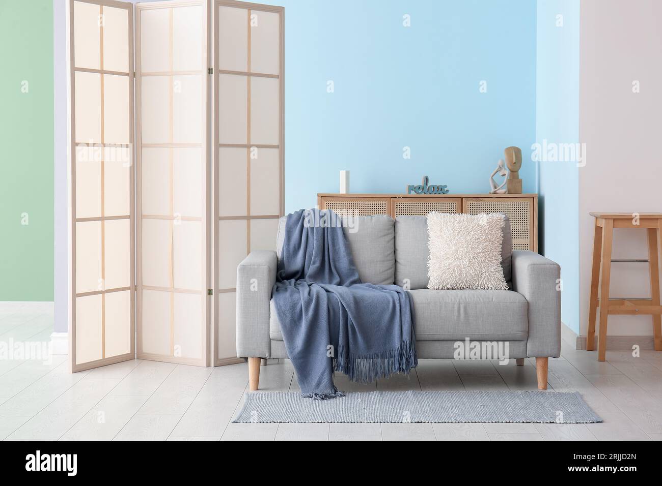 Modern living room interior with folding screen and grey sofa Stock ...