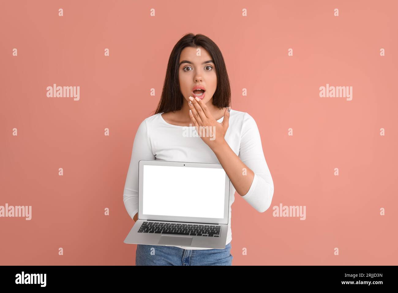 Shocked young female programmer with laptop on orange background Stock ...