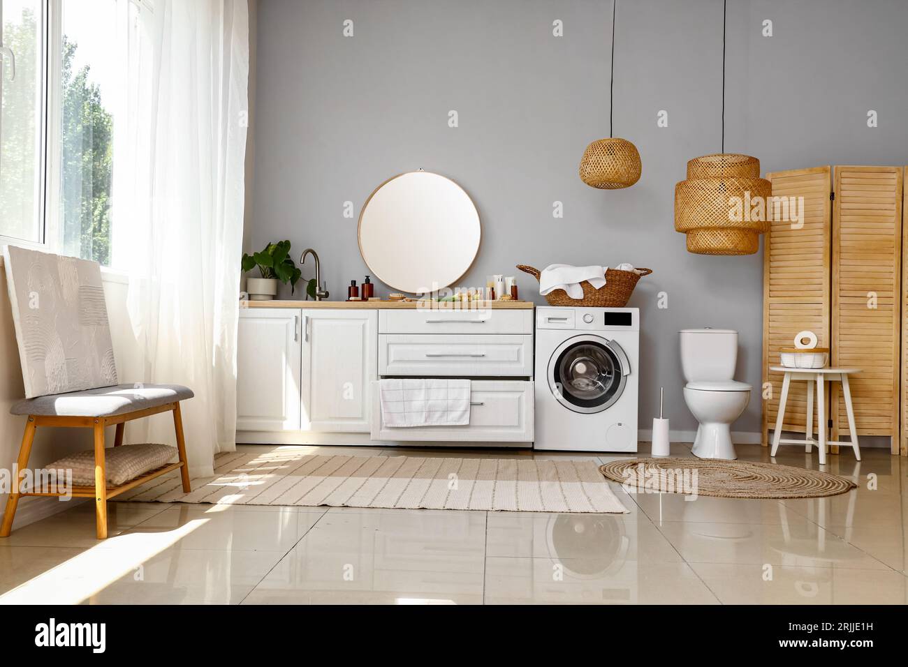 Interior of light restroom with ceramic toilet bowl, washing machine ...