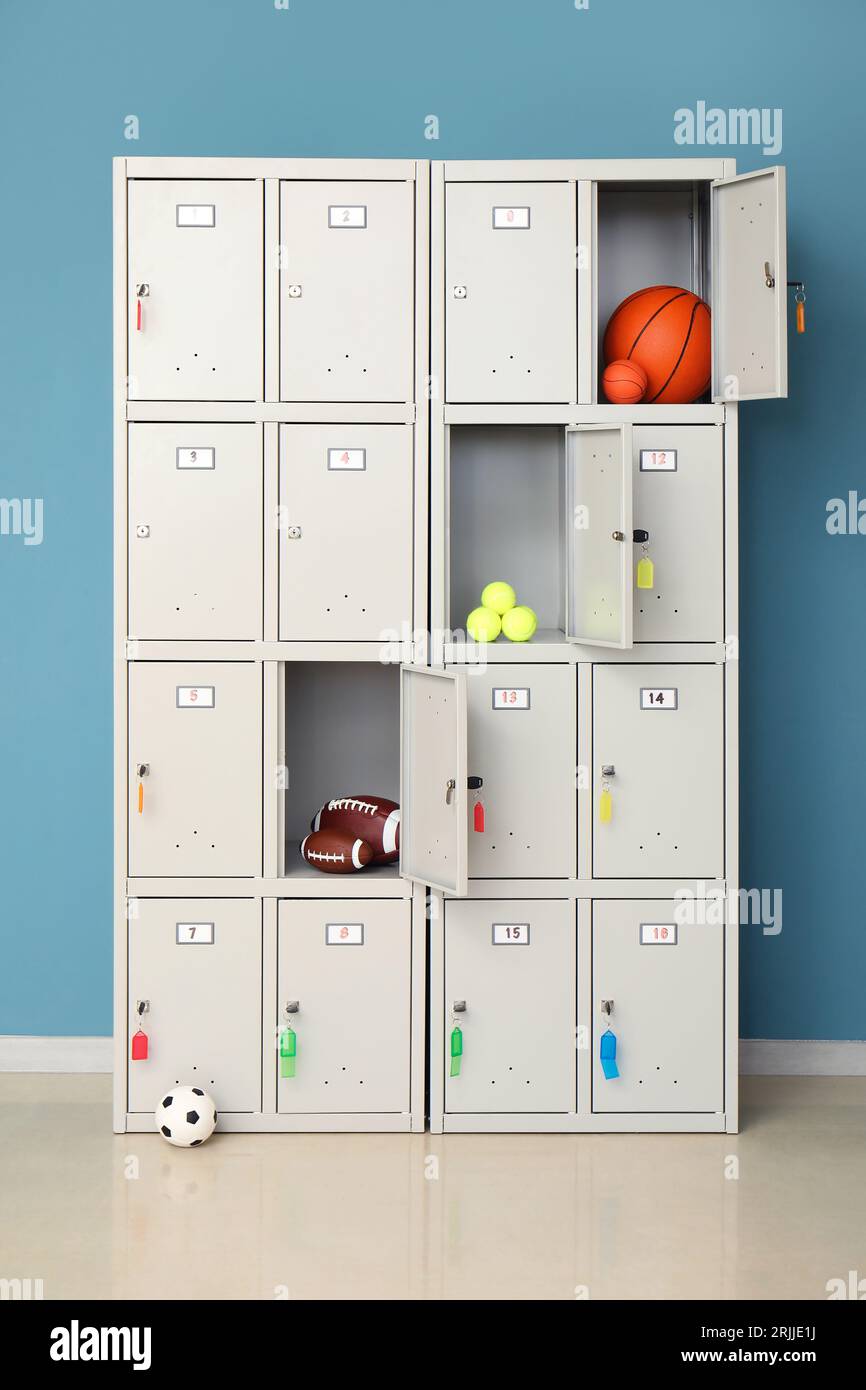 Modern locker with sports equipment near blue wall Stock Photo - Alamy