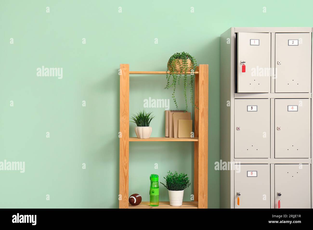Modern locker and shelving unit near green wall Stock Photo - Alamy