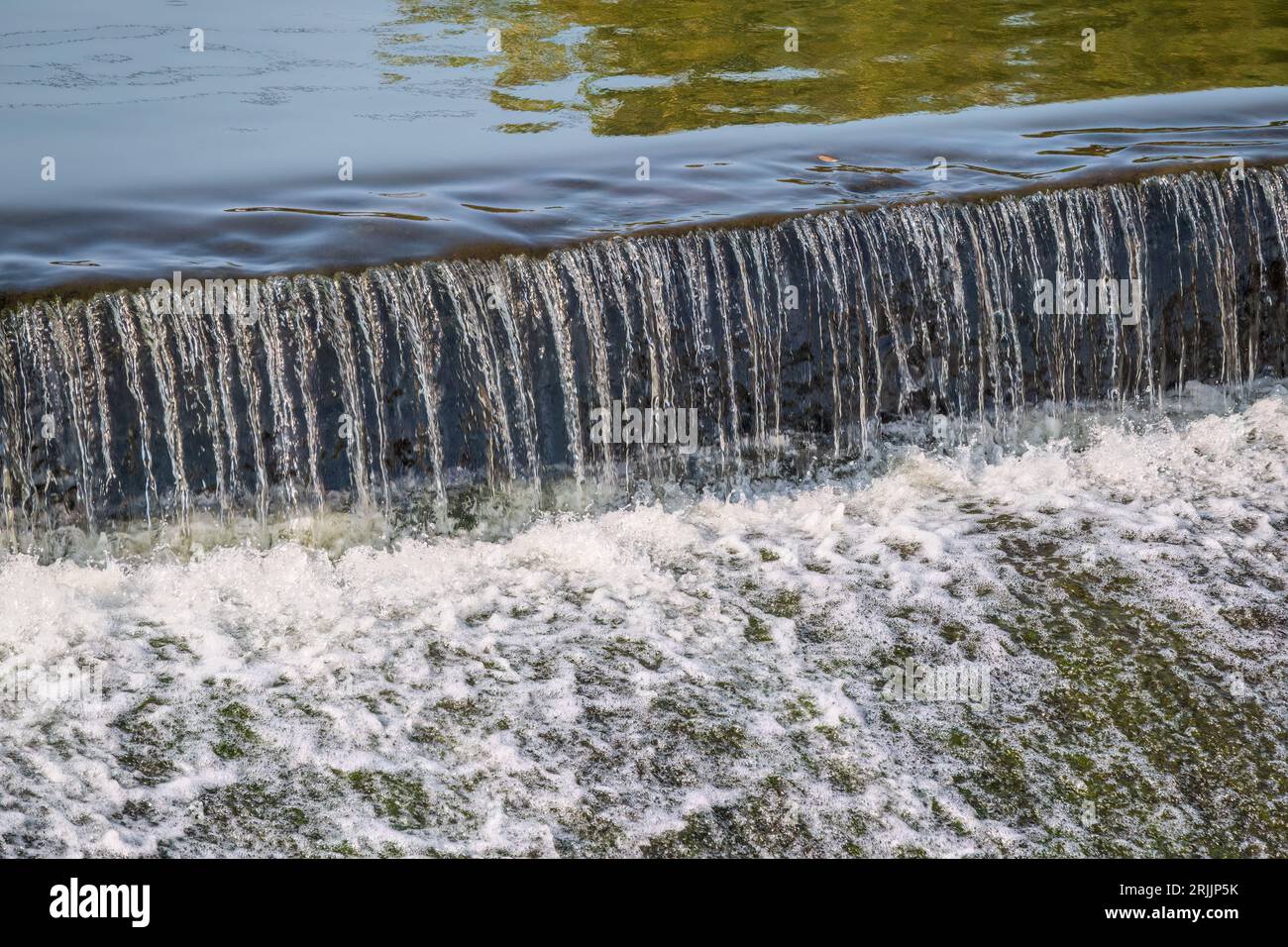 A small flat cascade in a calm river. Water background Stock Photo - Alamy