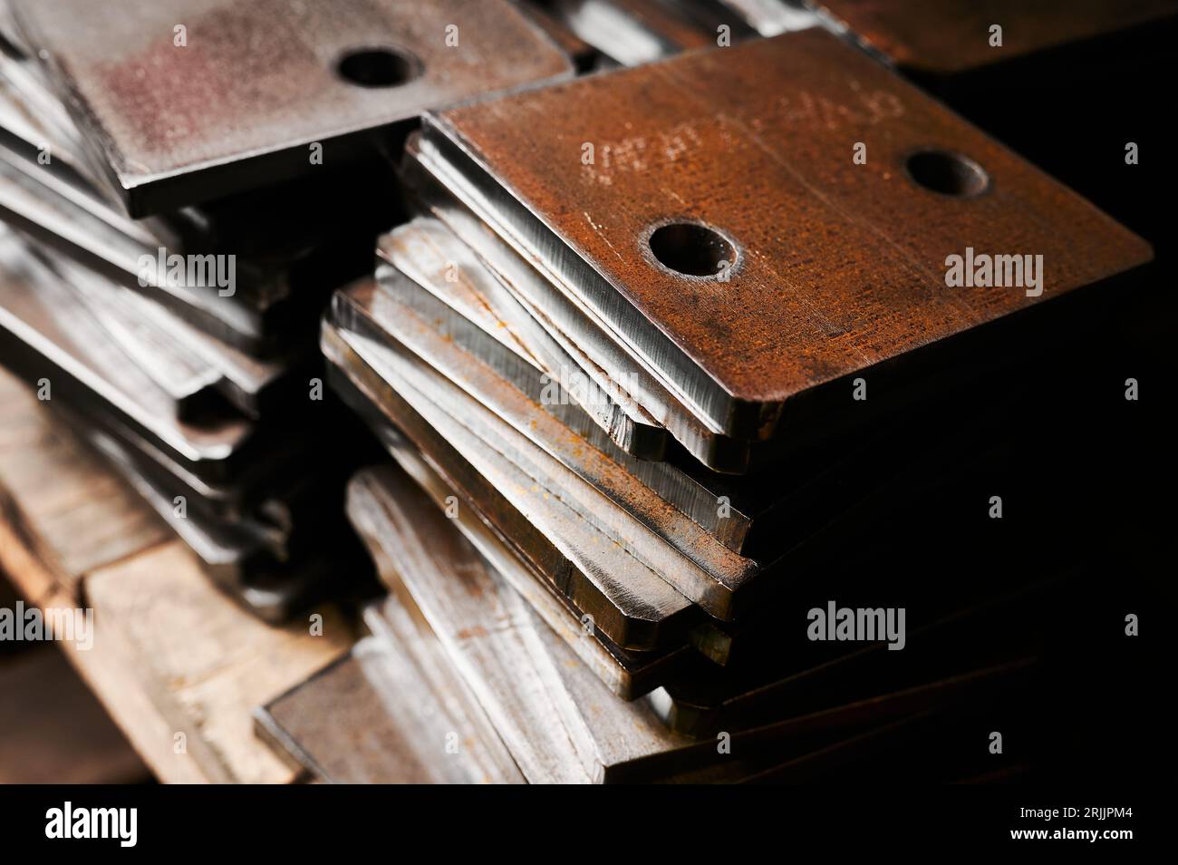 Stacks of metal plates with holes in plant storehouse Stock Photo - Alamy