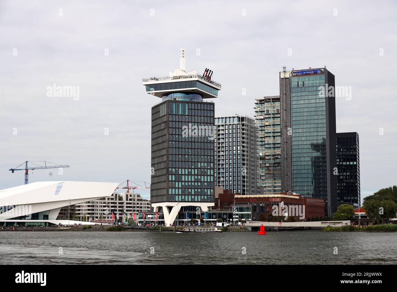 Office buildings in Amsterdam at the water IJ with ferry and tourist ...