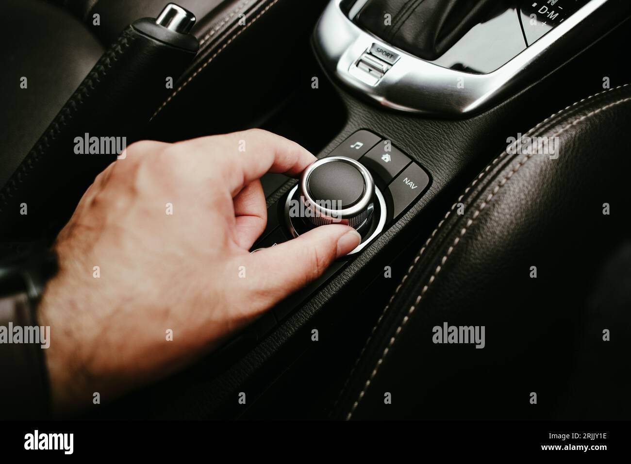A driver hand is turning button of car radio, human hand adjust a ...