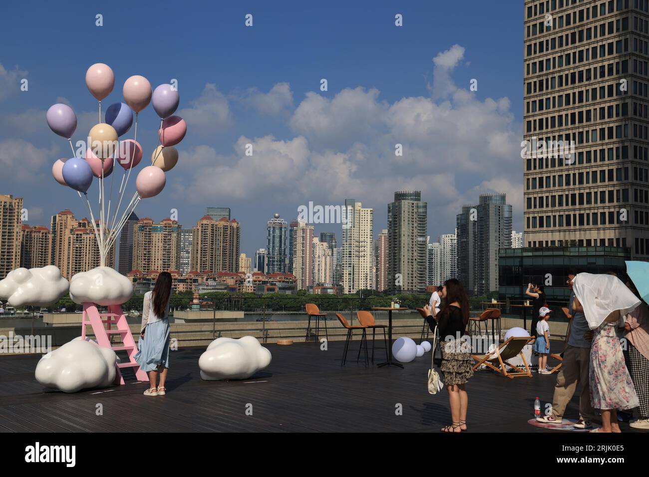 Tourists take photos of a large balloon art installation at the Bund in ...