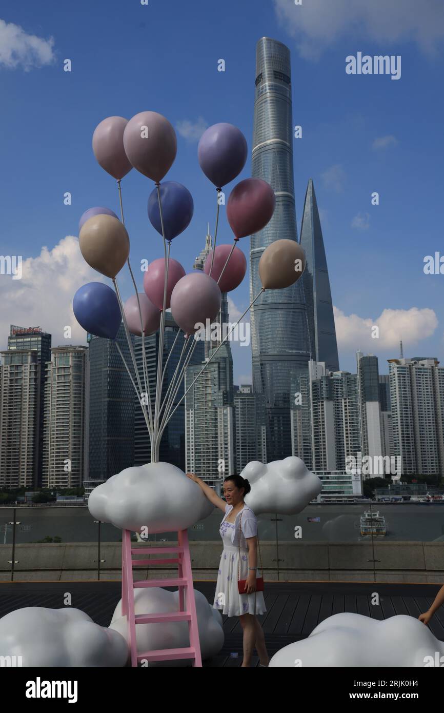 Tourists take photos of a large balloon art installation at the Bund in ...
