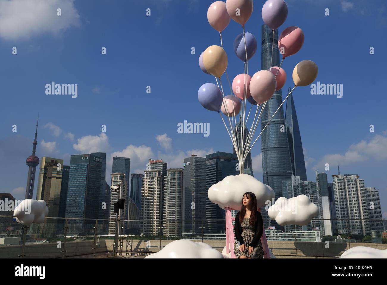 Tourists take photos of a large balloon art installation at the Bund in ...