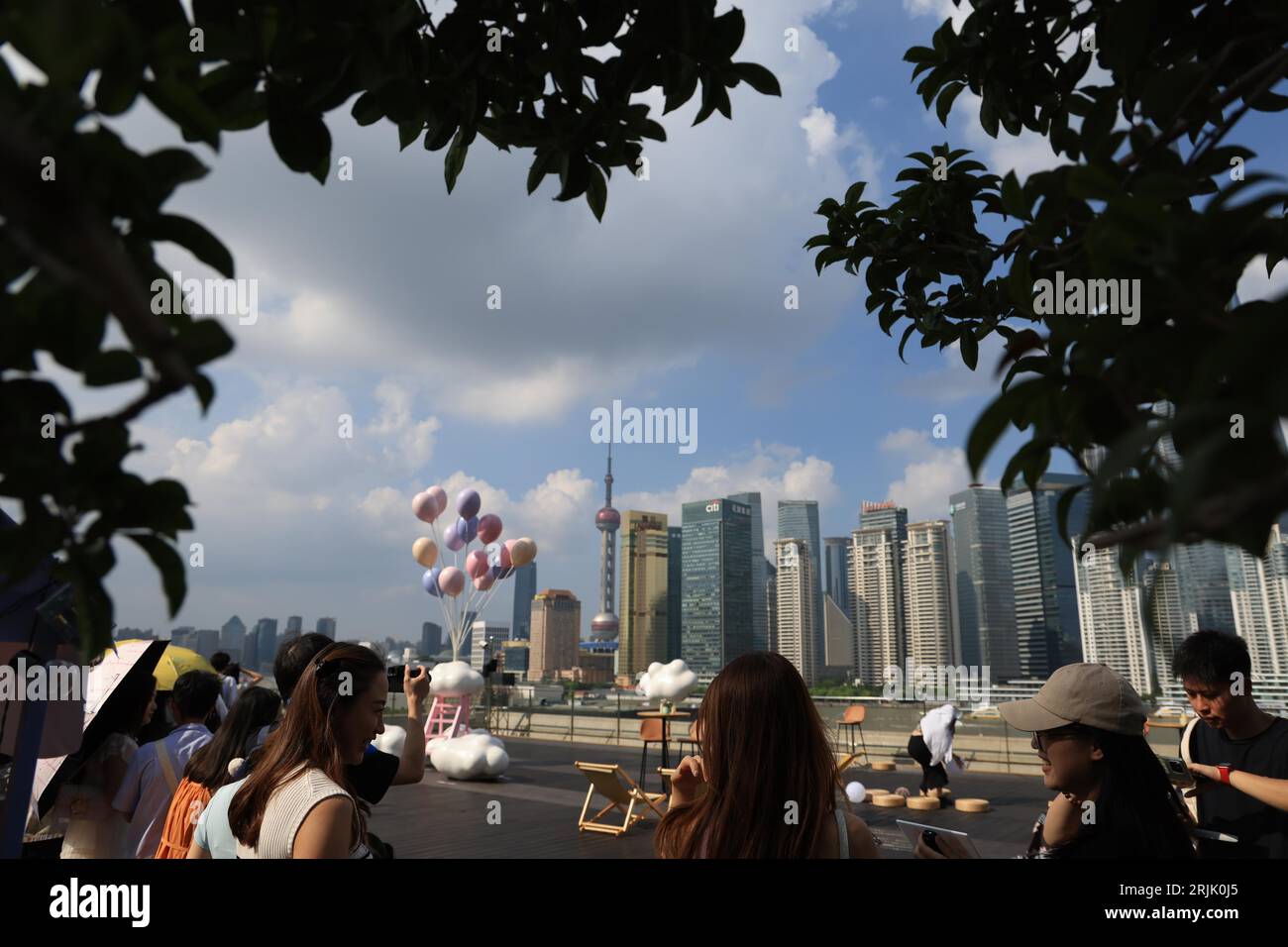 Tourists take photos of a large balloon art installation at the Bund in ...