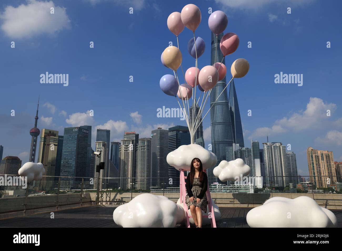 Tourists take photos of a large balloon art installation at the Bund in ...