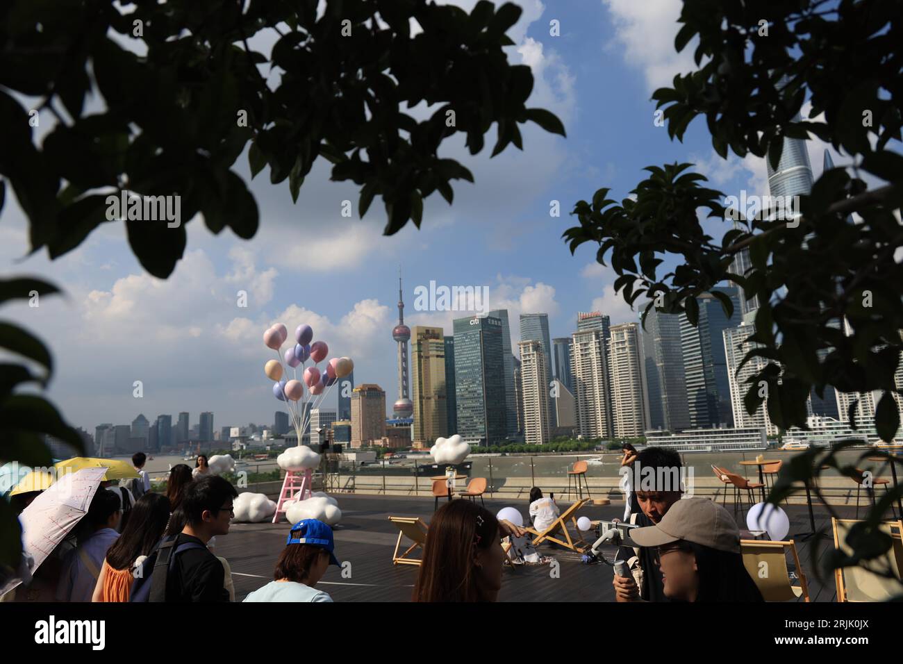 Tourists take photos of a large balloon art installation at the Bund in ...