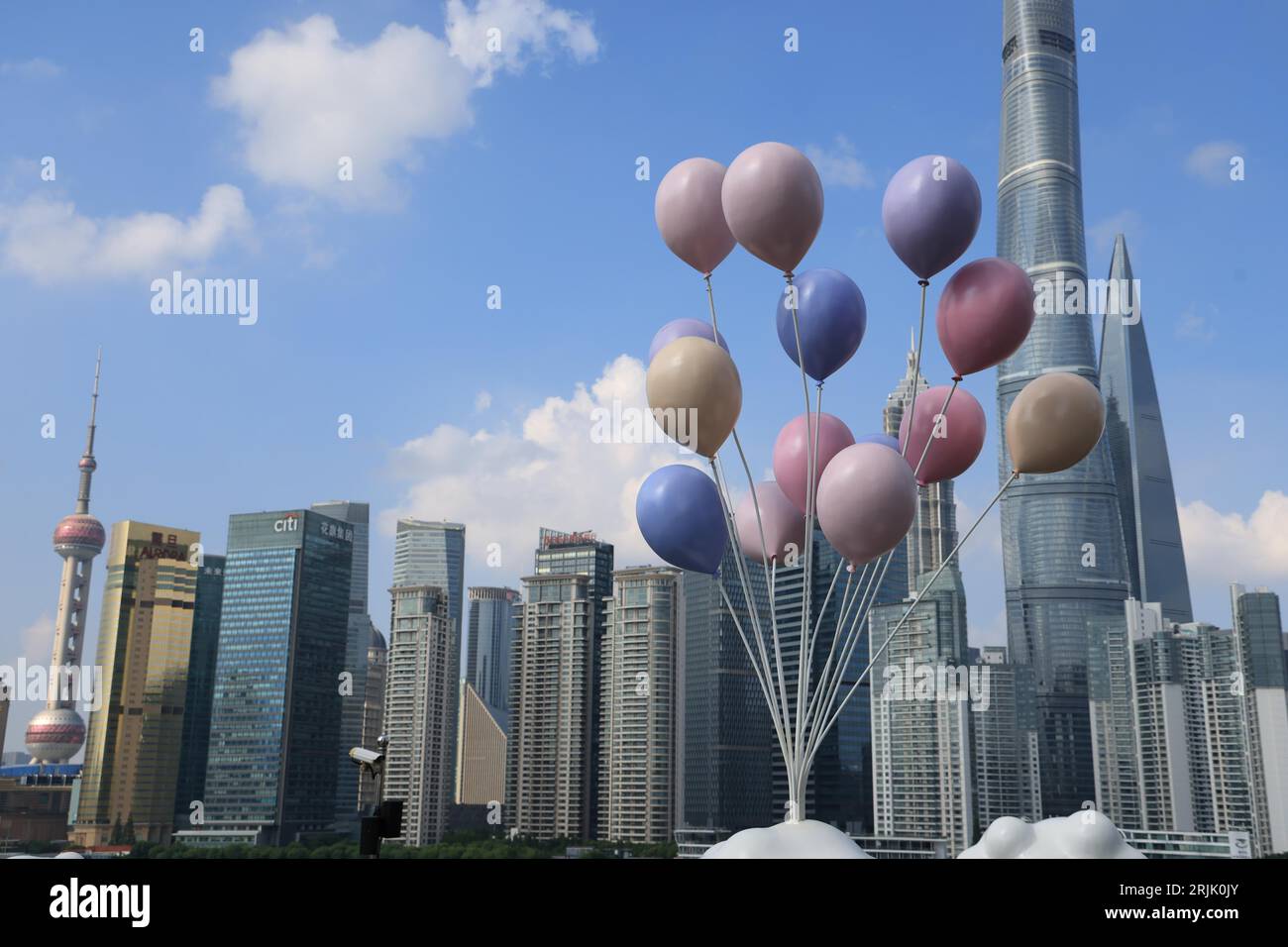 Tourists take photos of a large balloon art installation at the Bund in ...