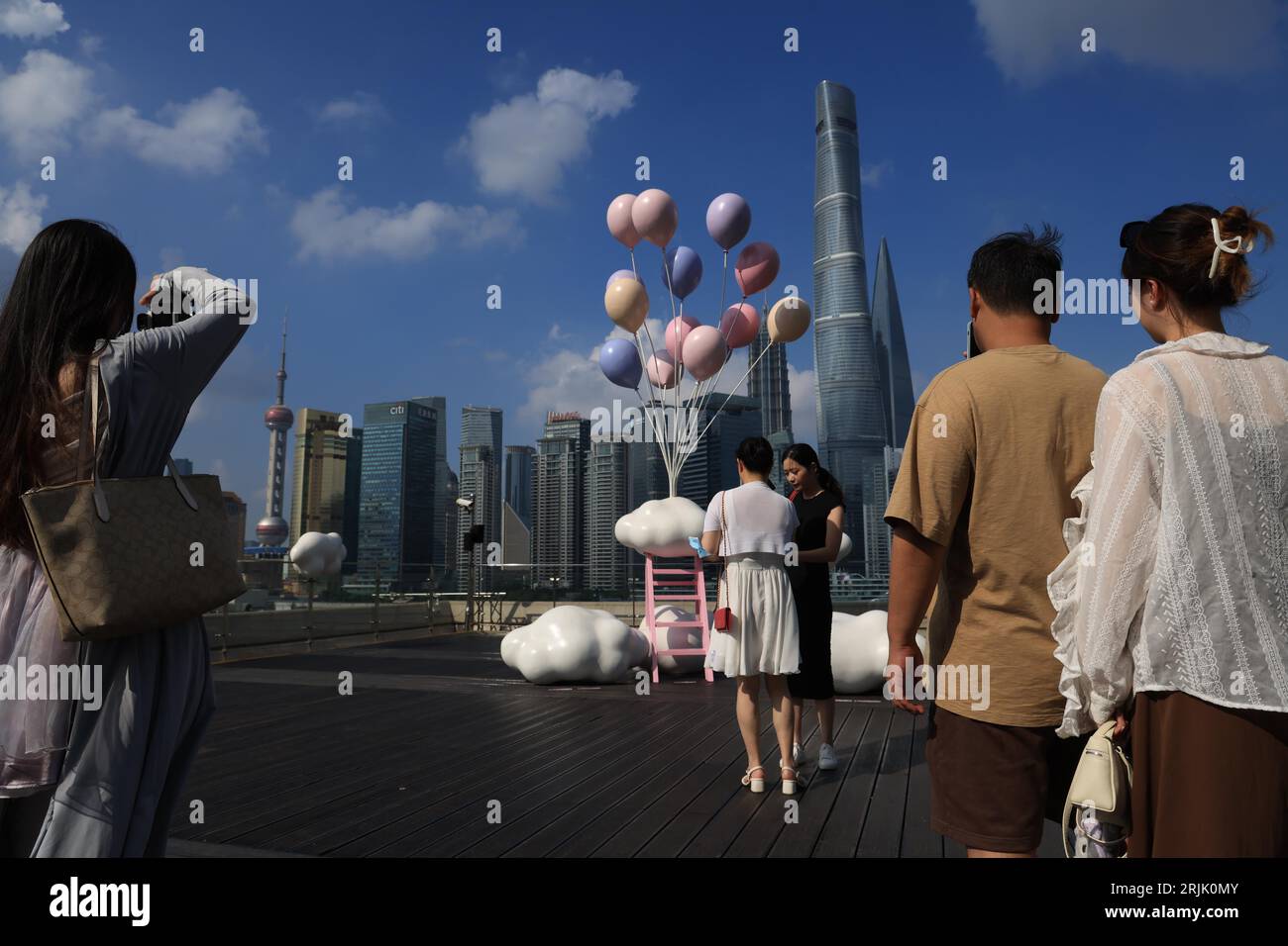 Tourists take photos of a large balloon art installation at the Bund in ...