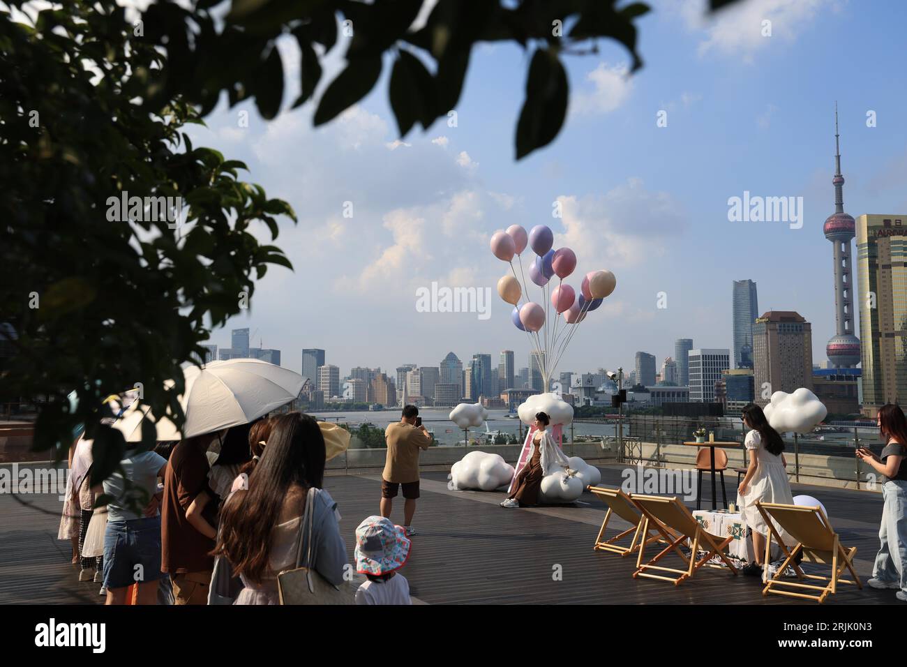 Tourists take photos of a large balloon art installation at the Bund in ...