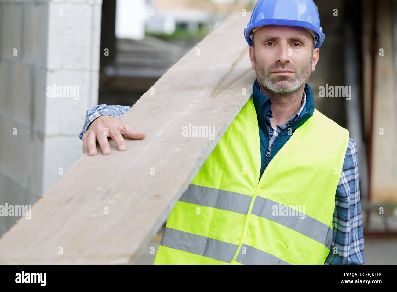 man as builder carrying wood and working Stock Photo - Alamy