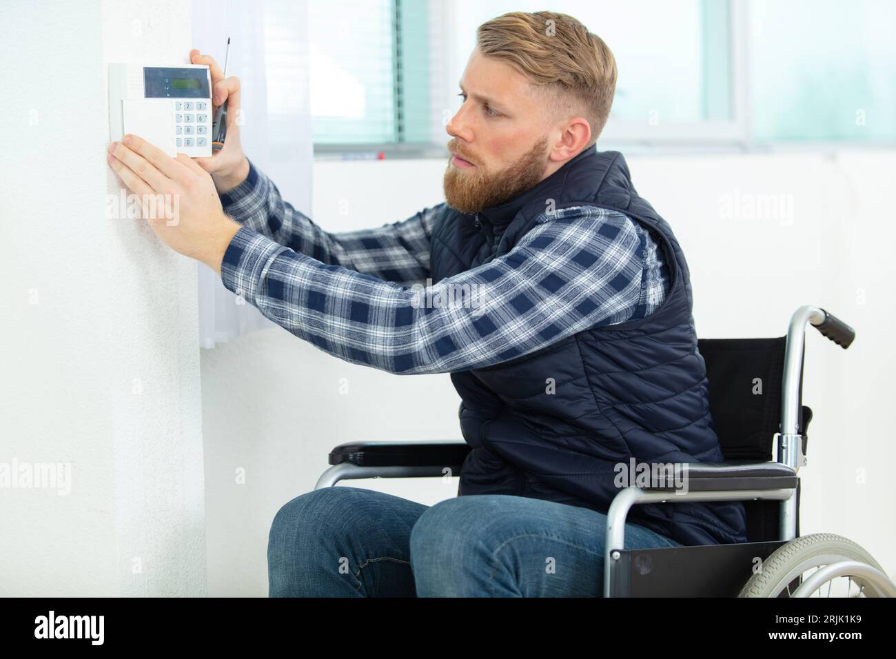 disabled electrician installing alarm system Stock Photo - Alamy